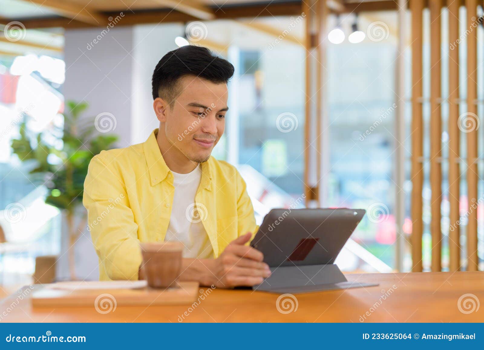 Young Man at Coffee Shop Using Digital Tablet Computer Stock Photo ...