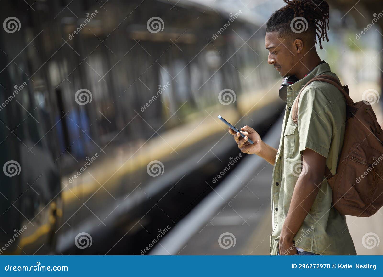 Young Man Commuting To Work on Train Standing on Platform Looking at ...