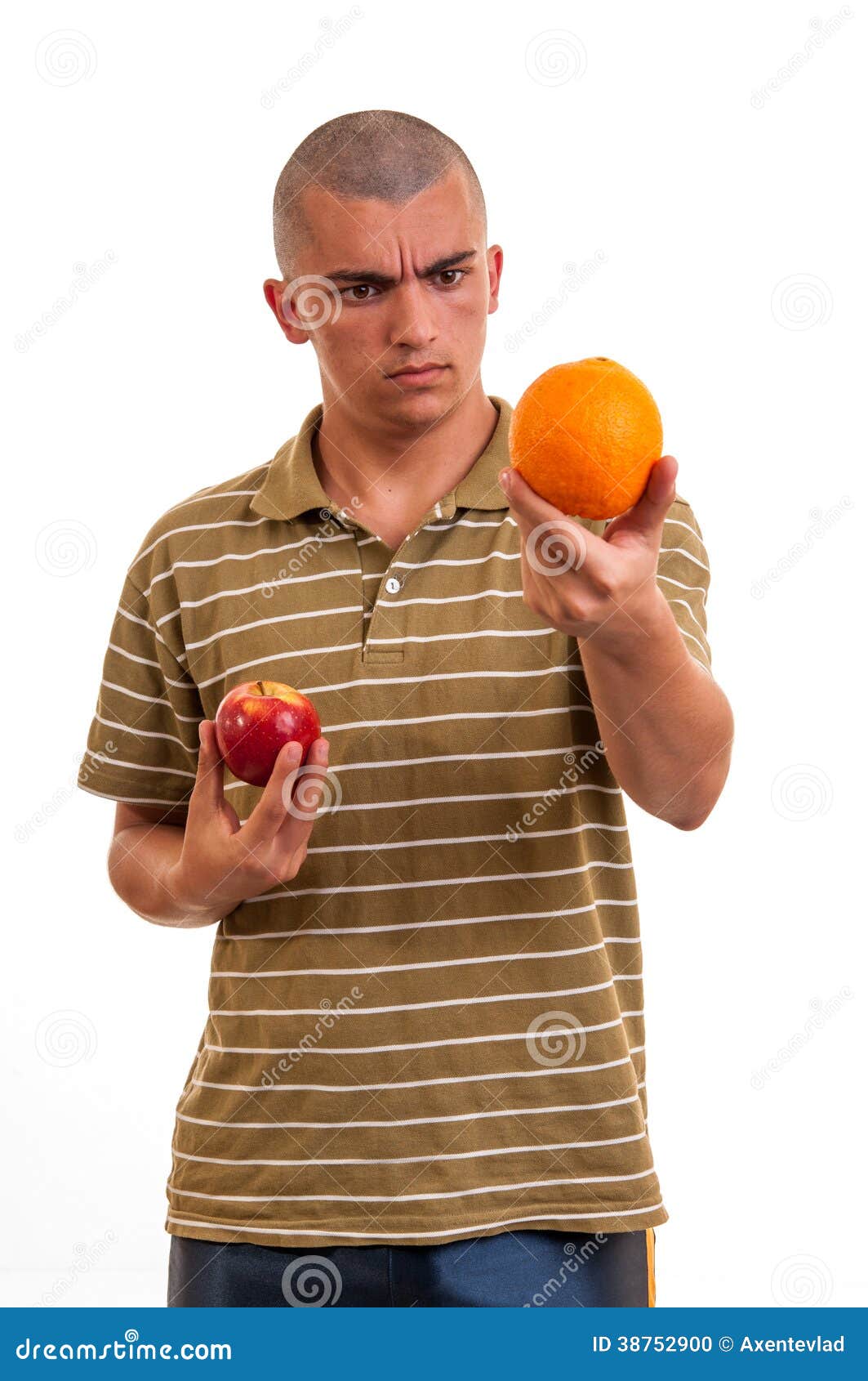 Young Man Comparing Orange To Apple Stock Photo - Image of confused ...