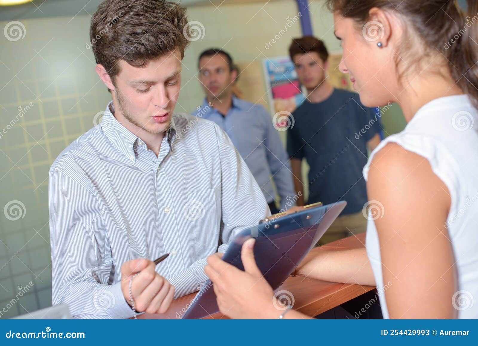 Young Man Completing Form at Reception Stock Image - Image of reception ...
