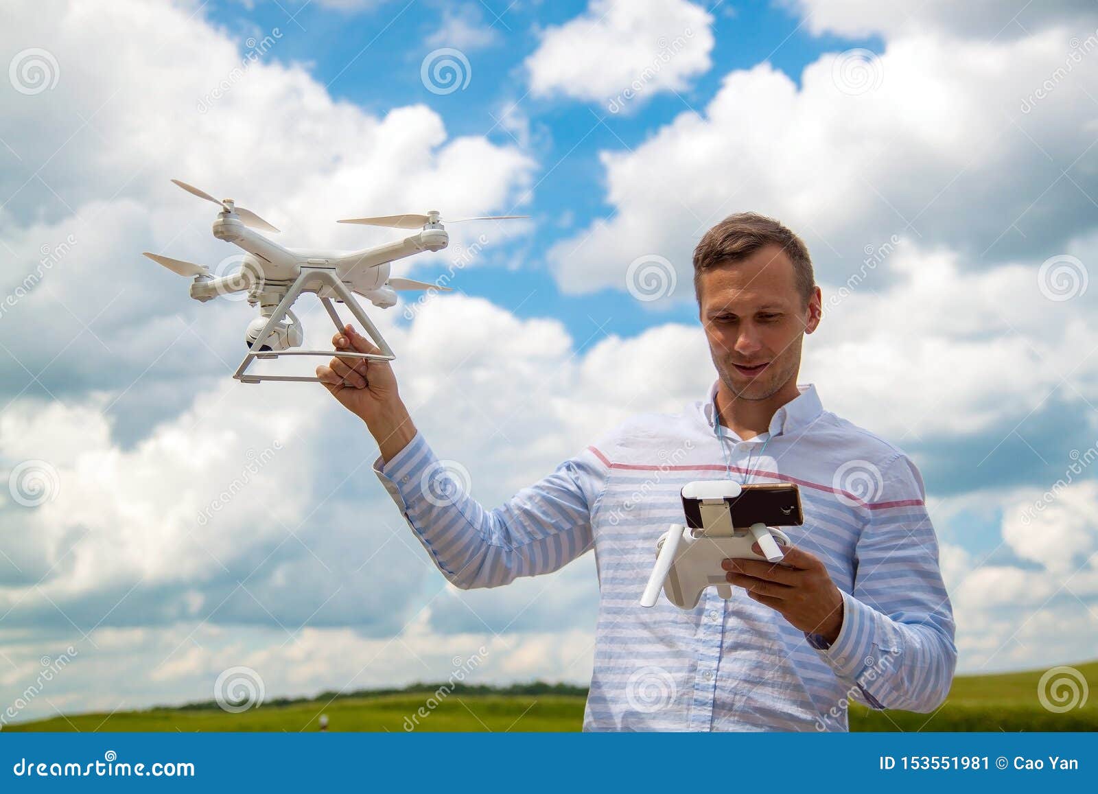 Young Man Controlling Drone in Field. Drone Operator Holding a ...