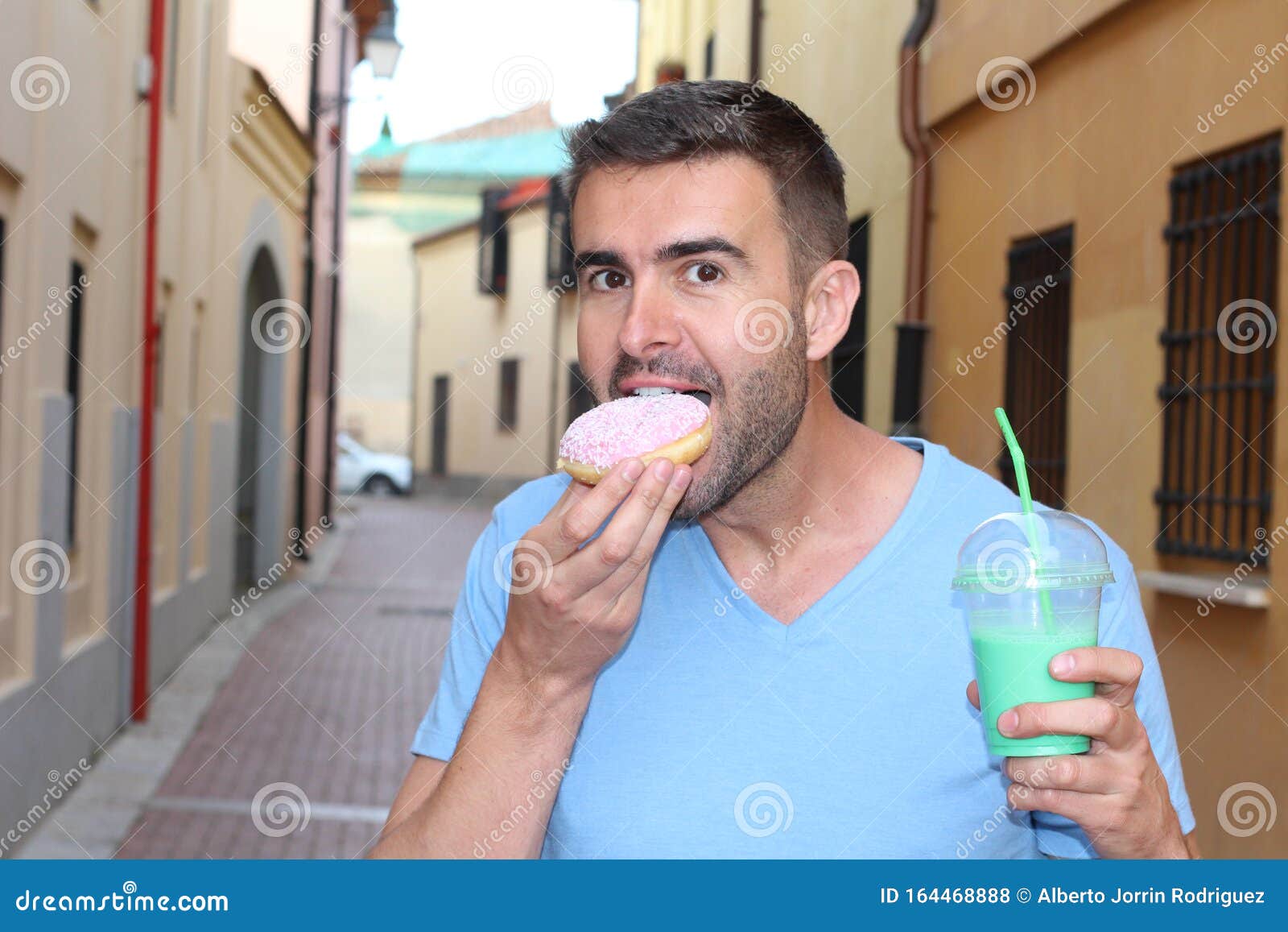 Young man craving a donut stock photo. Image of care - 164468888