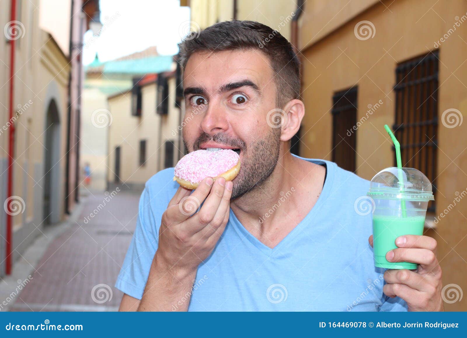 Young man craving a donut stock photo. Image of adult - 164469078