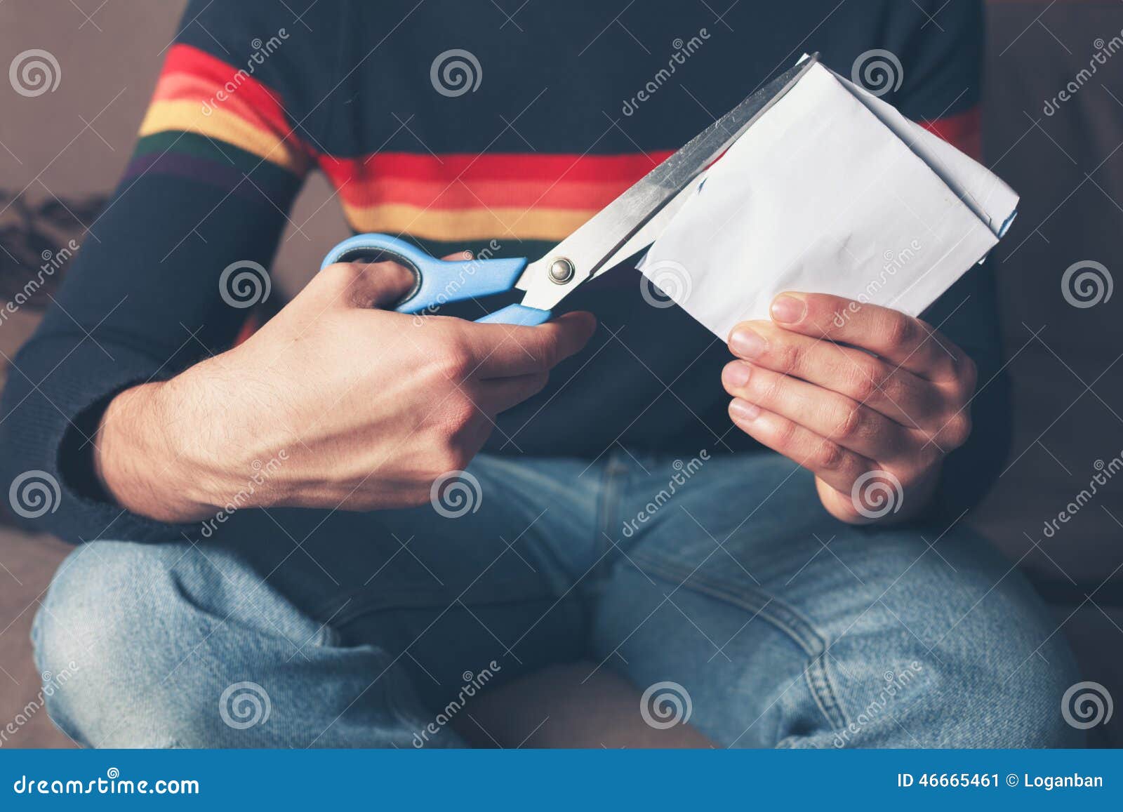 Young man cutting up paper stock image. Image of home - 46665461