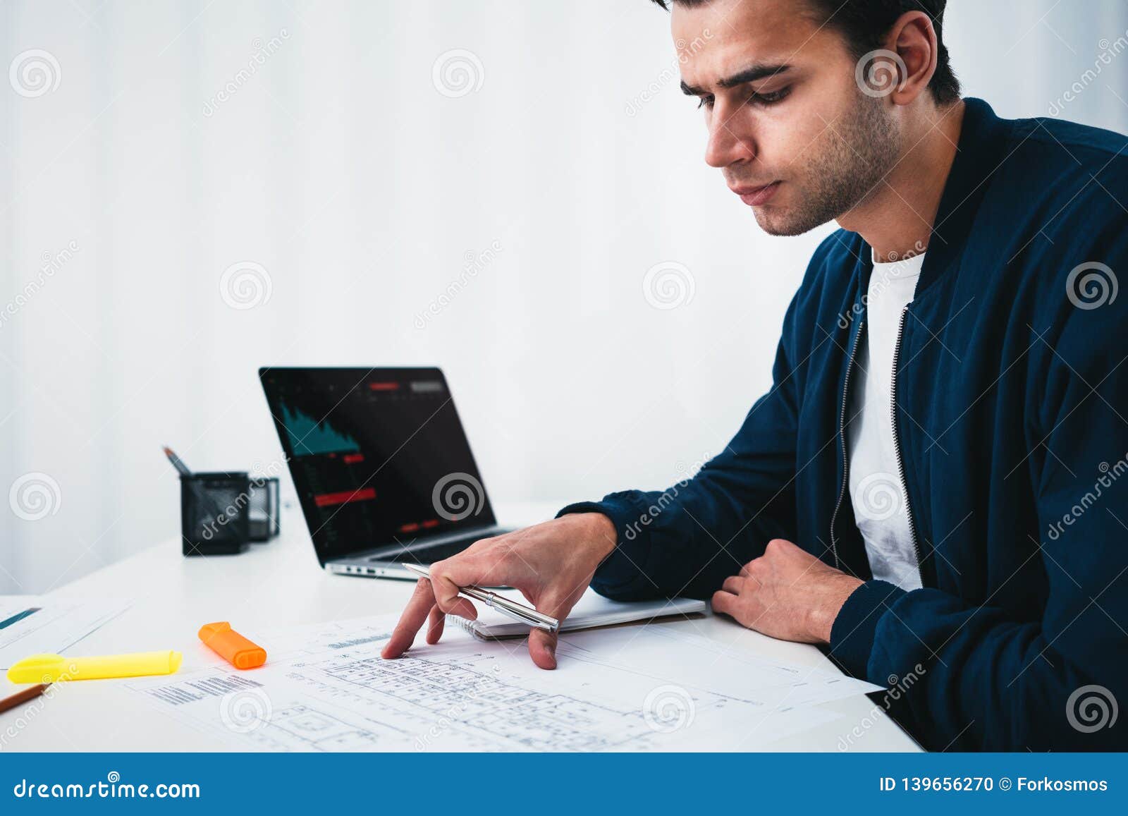 Young Man Designer Sketching a Construction Project at Notebook and ...