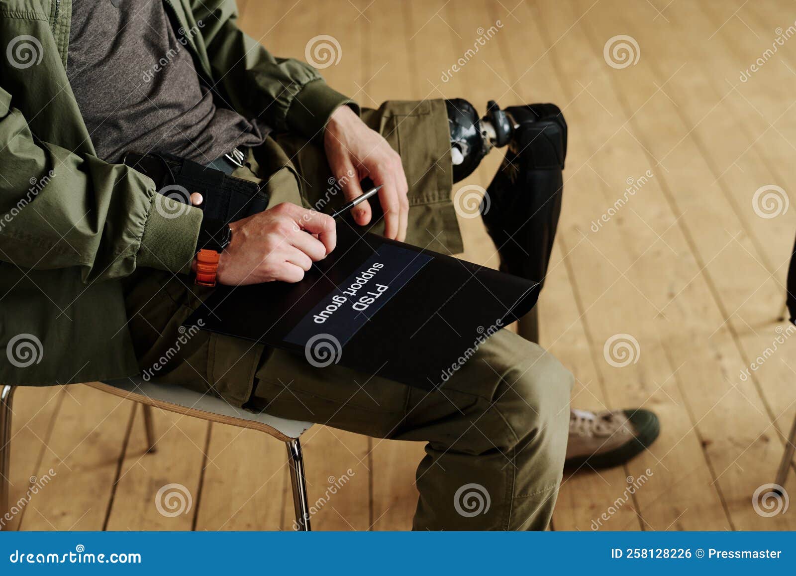 Young Man with Disability Holding Black Folder of PTSD Support Group ...