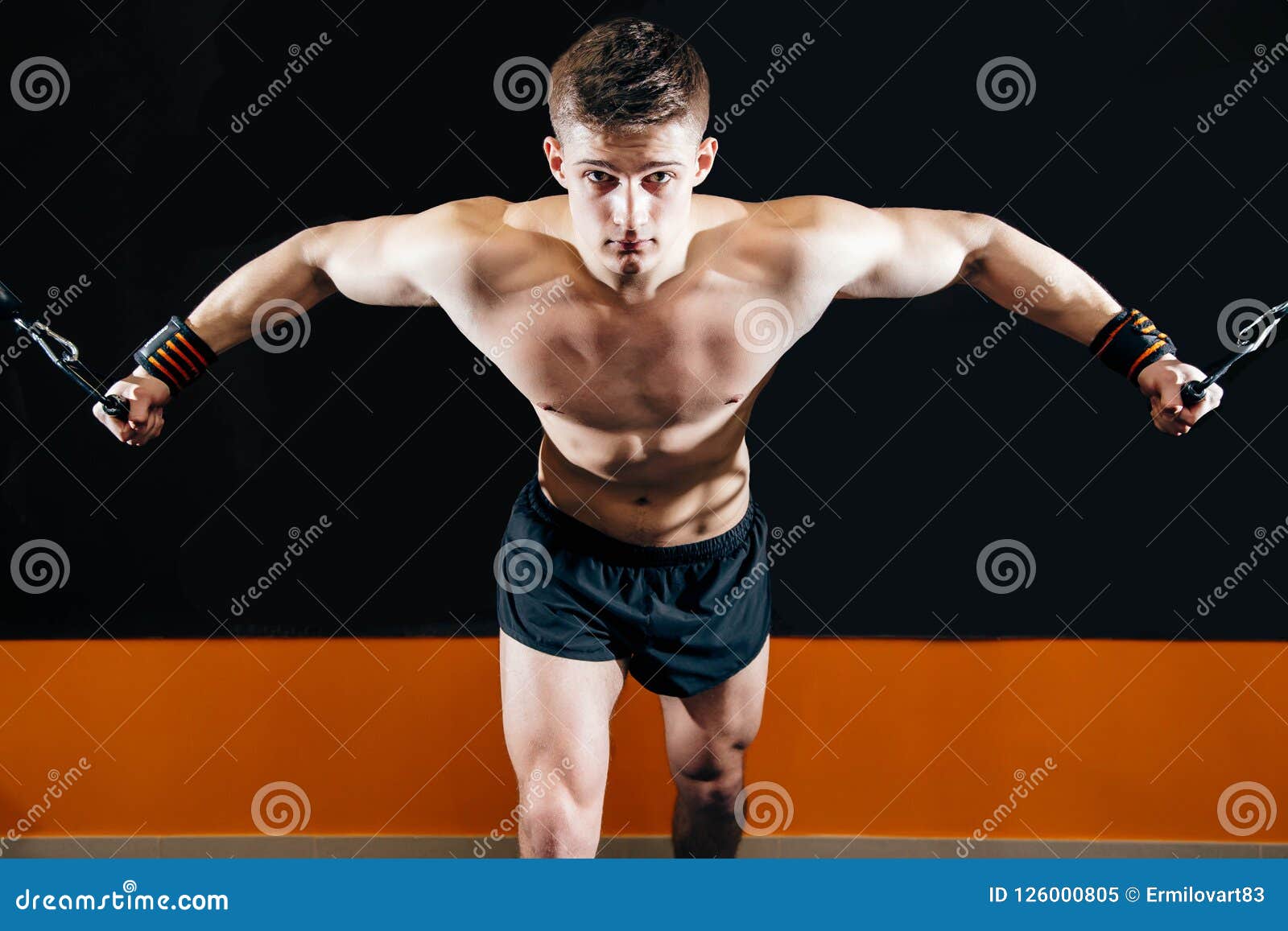 A Young Man Does Hand-cutting on the Simulator in the Gym. Exercise for ...