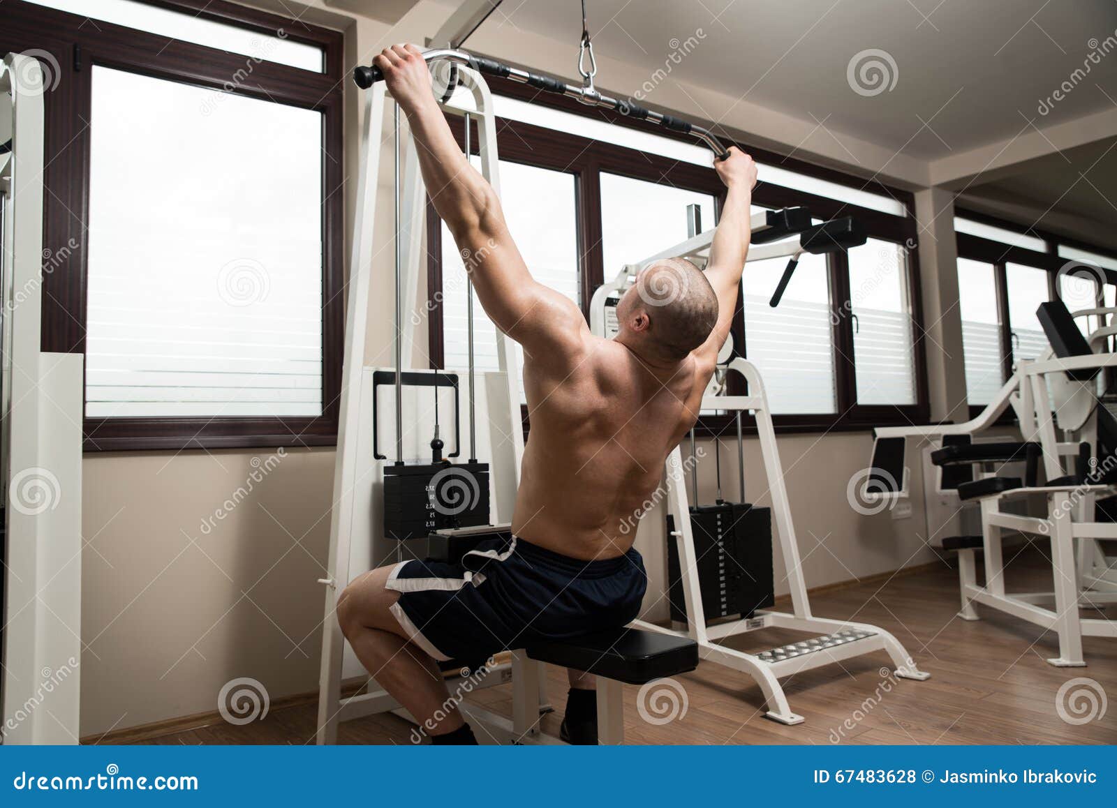 Young Man Doing Back Exercise on a Machine Stock Photo - Image of ...