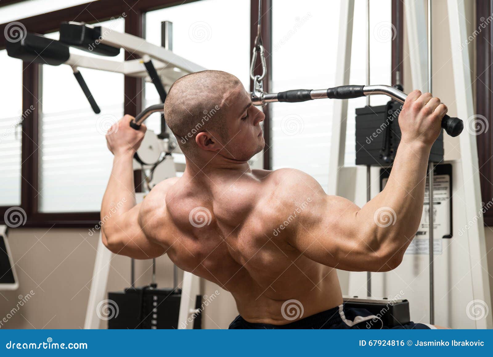 Young Man Doing Back Exercise on a Machine Stock Photo - Image of ...