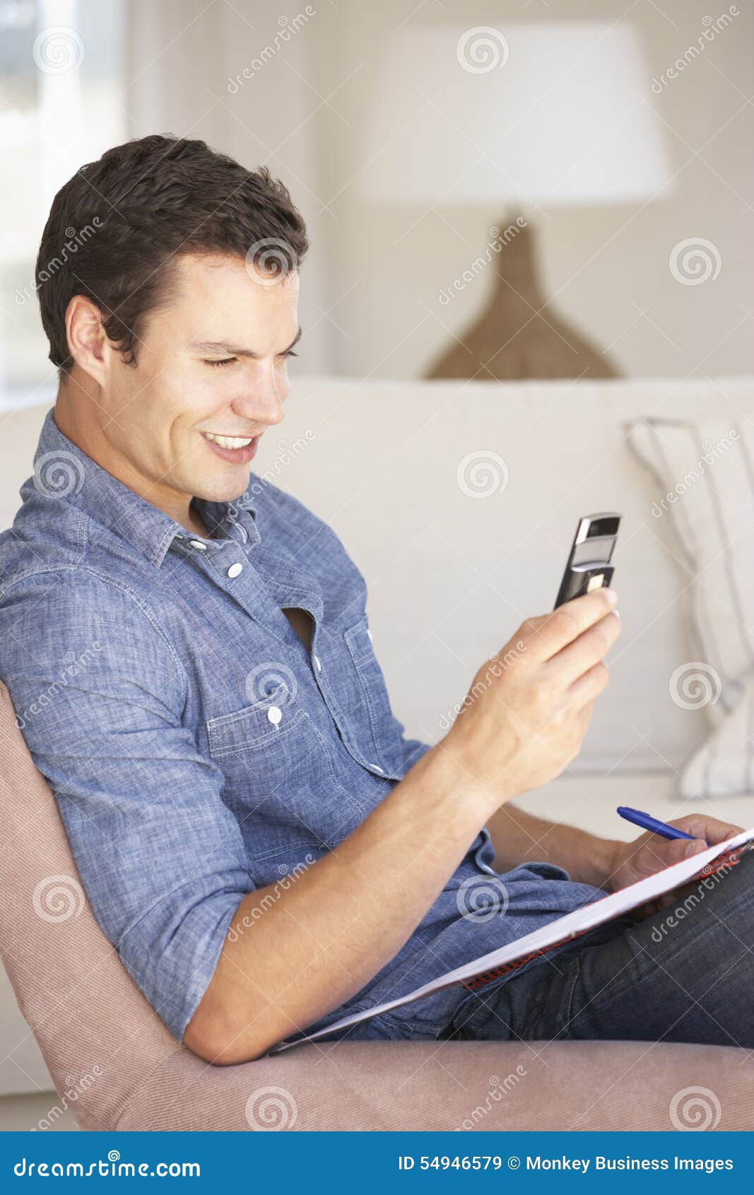 Young Man Doing Paperwork and Using Mobile Phone at Home Stock Image ...