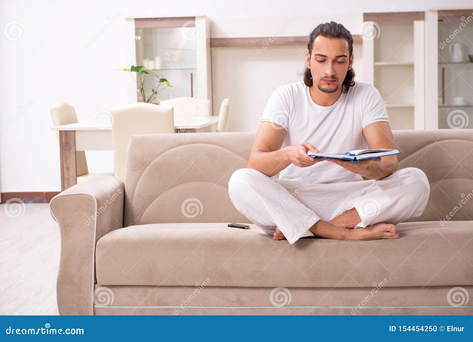 Young Man Doing Physical Exercises at Home Stock Photo - Image of book ...