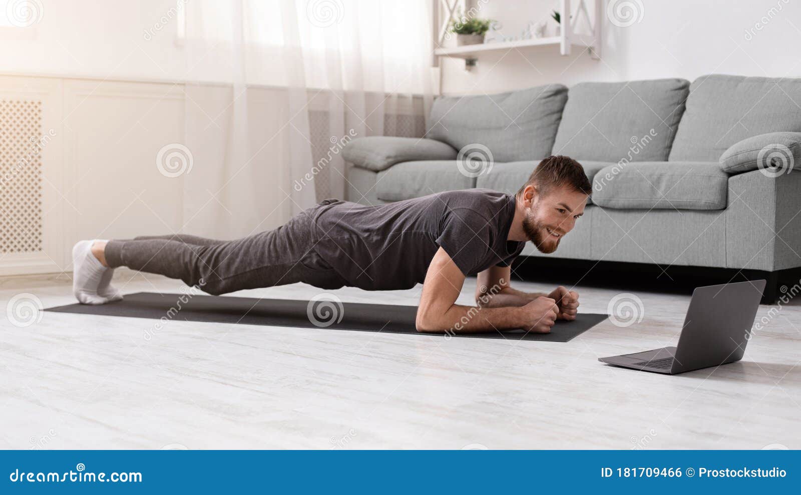 Young Man Doing Plank Exercise with Online Tutorial at Home Stock Photo ...