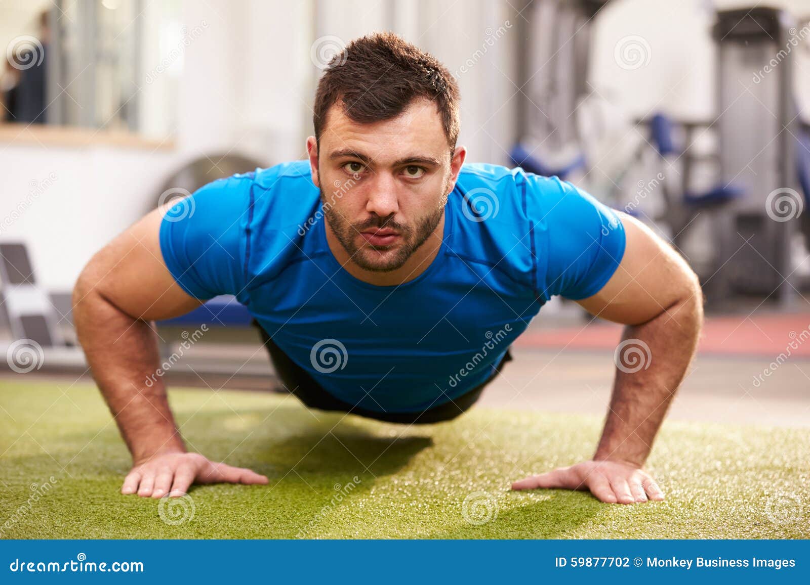 Young Man Doing Push Ups at a Gym, Looking To Camera Stock Photo ...