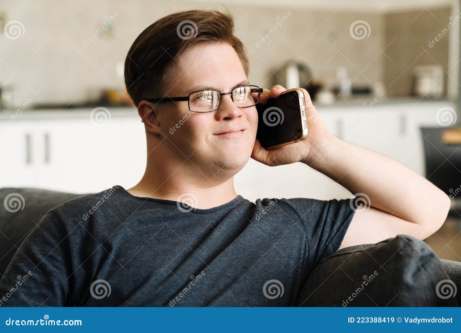 Man with Down Syndrome Talking on Cellphone while Sitting at Home Stock ...