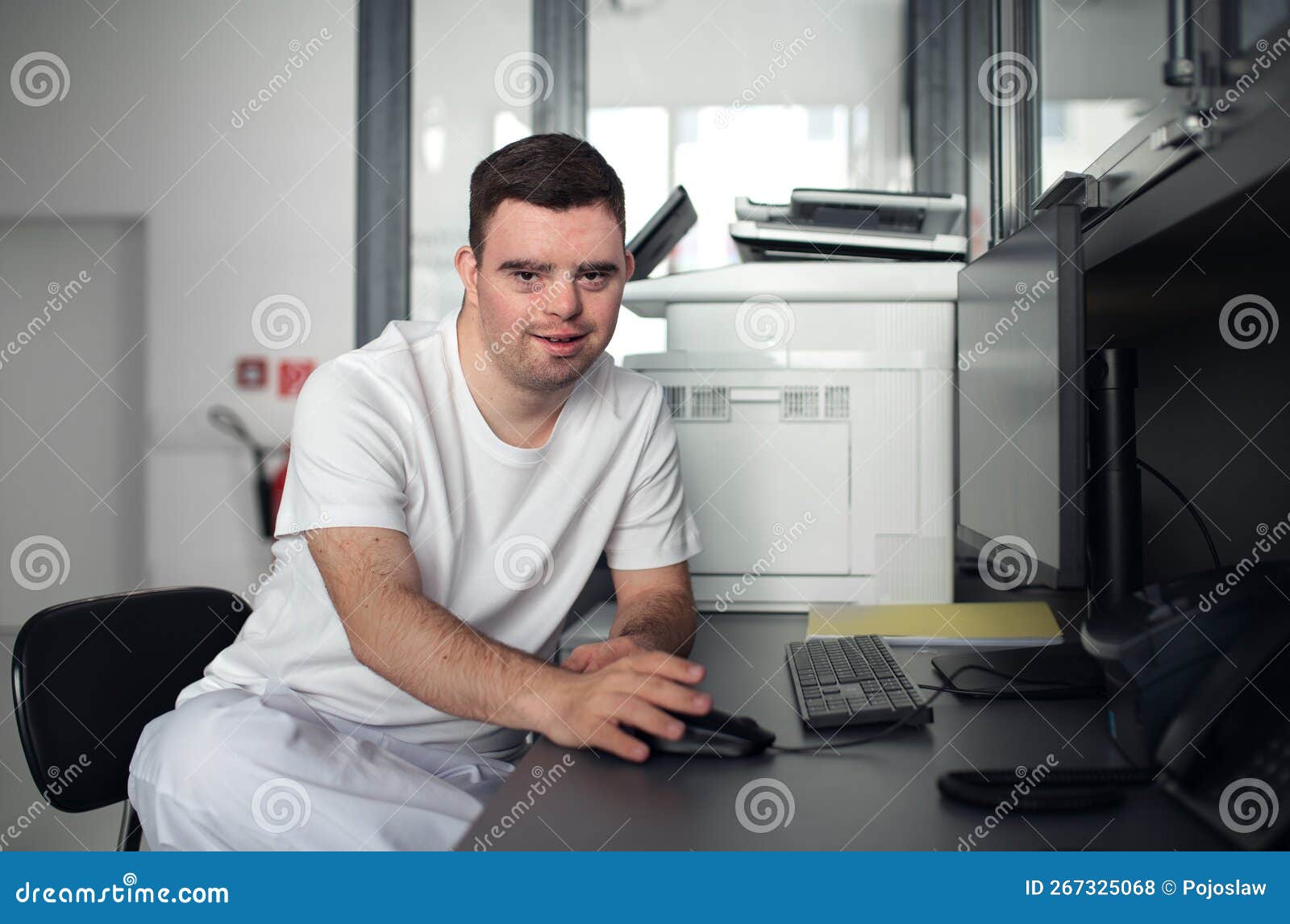 Young Man with Down Syndrome Working in Hospital Office, Writing ...