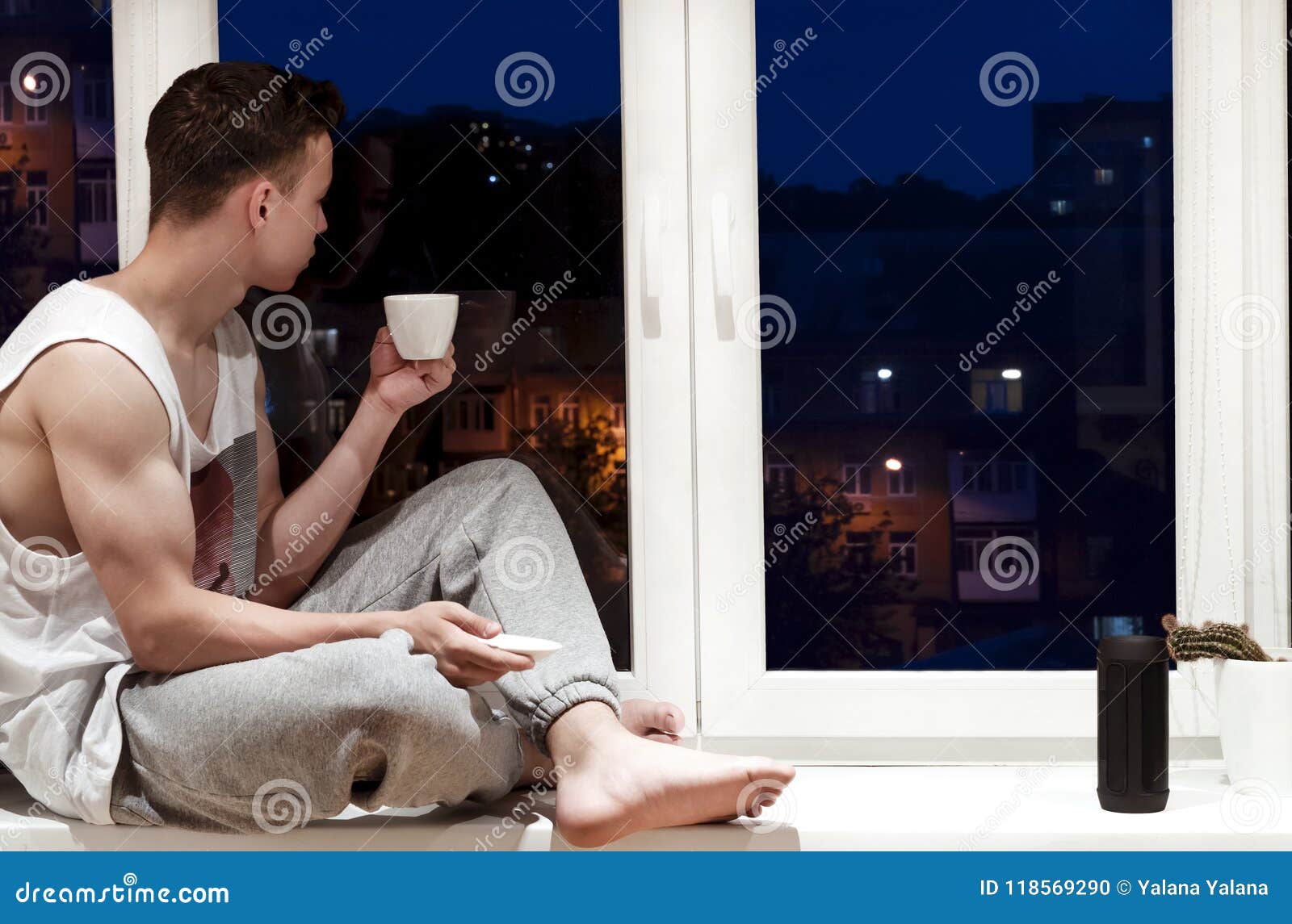 Handsome Young Man Sitting Near Window in the Evening Stock Photo ...