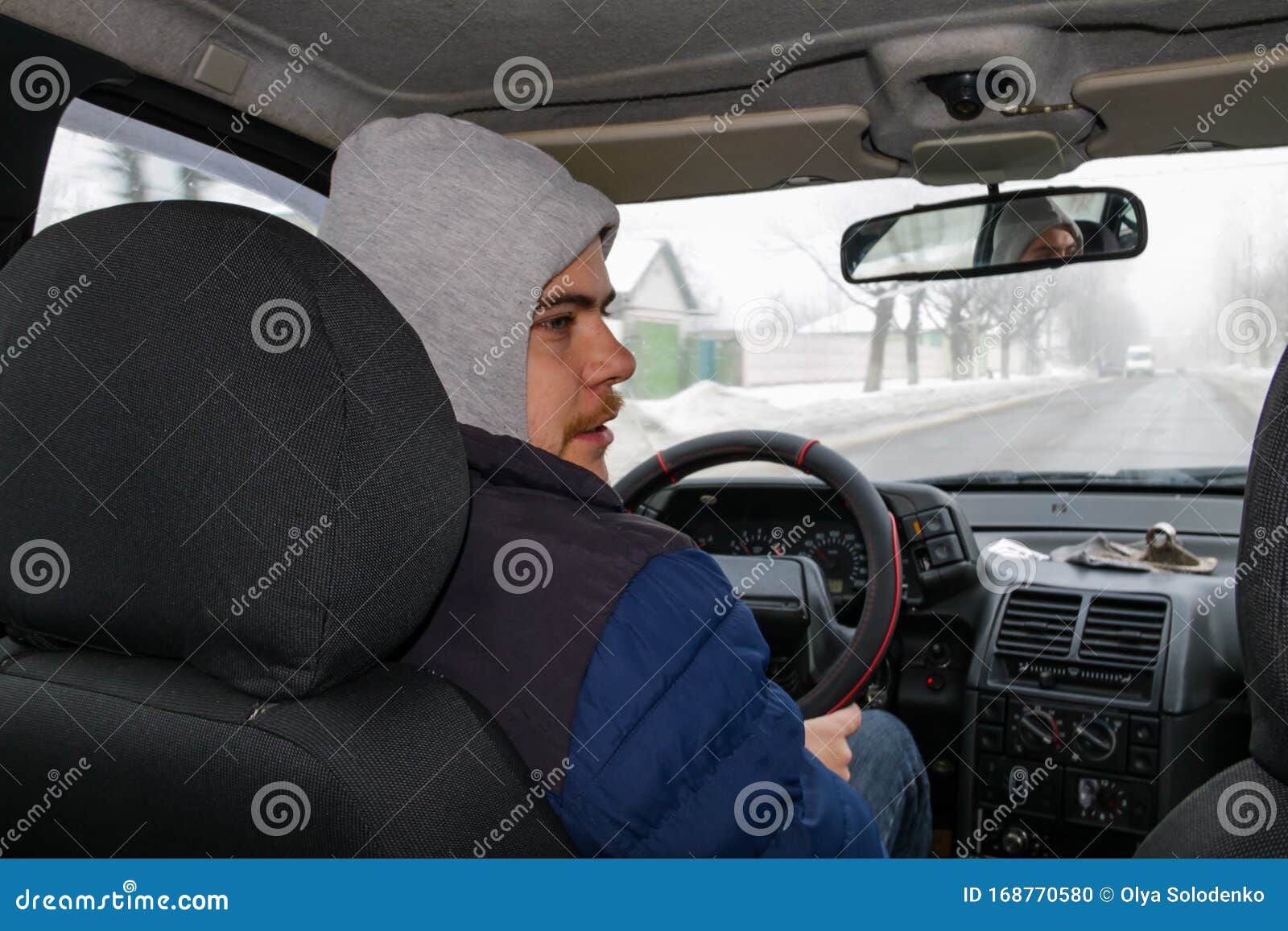 Young Man Driving a Car on Winter Road. Inside View Stock Photo - Image ...