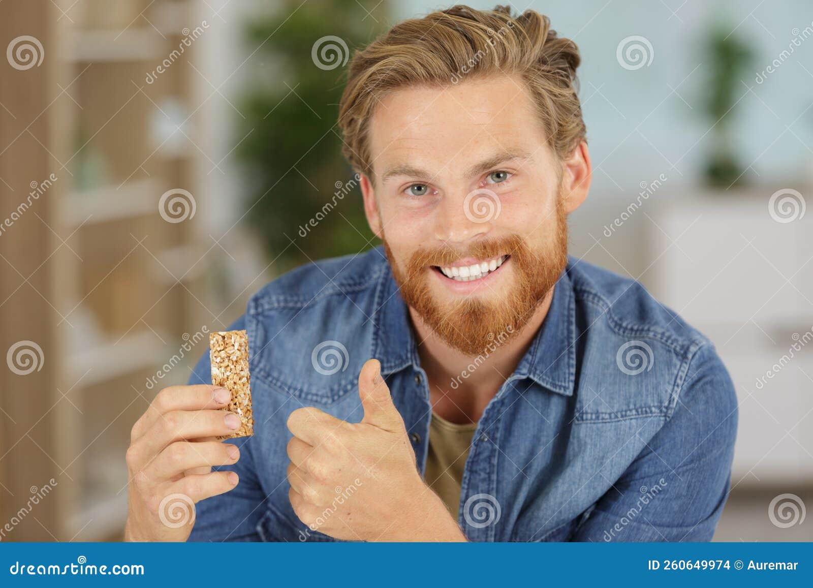 Young Man Eating Cereal Bar Stock Photo - Image of person, snack: 260649974