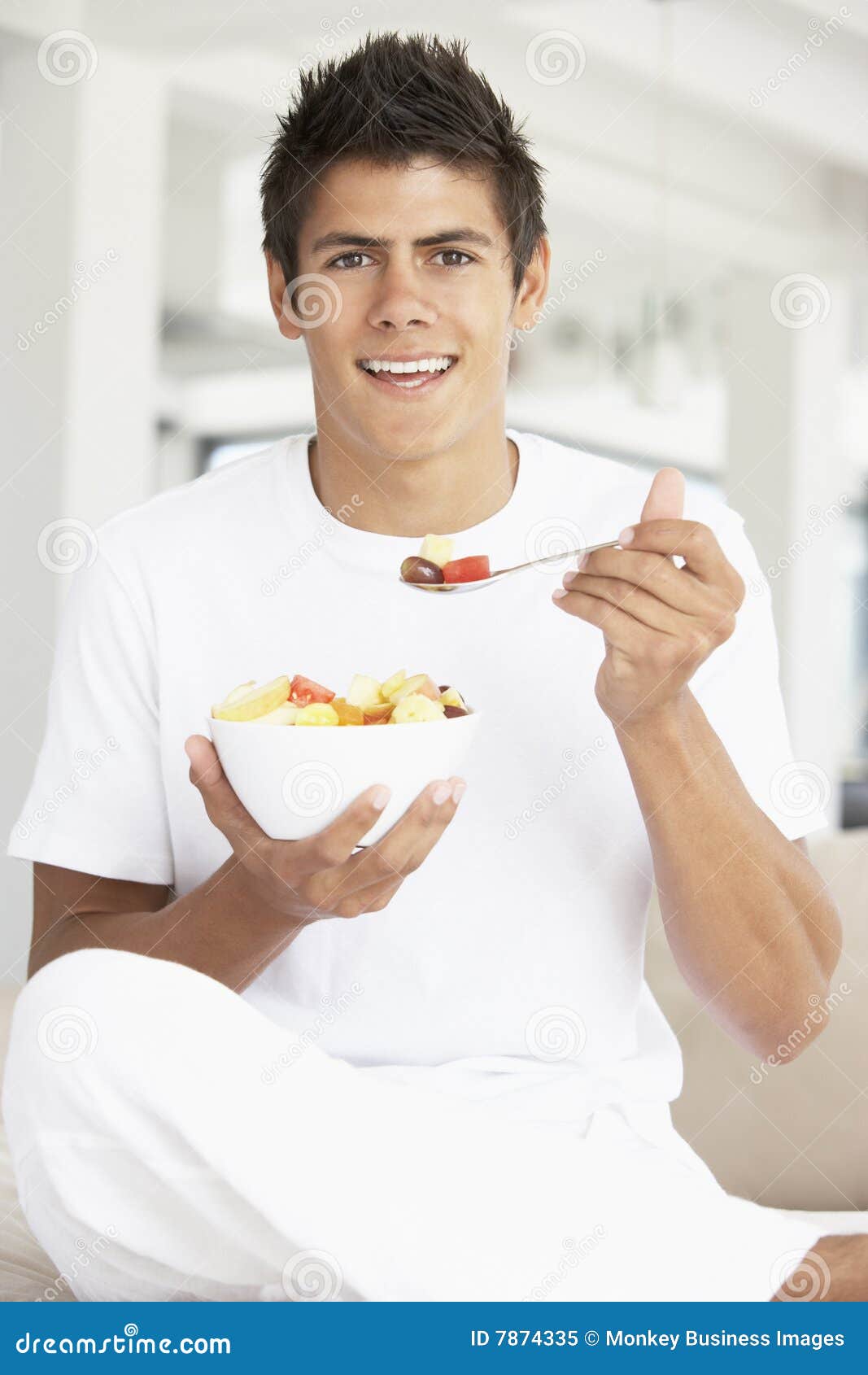 Young Man Eating Fresh Fruit Salad Stock Image - Image of smiling, home ...