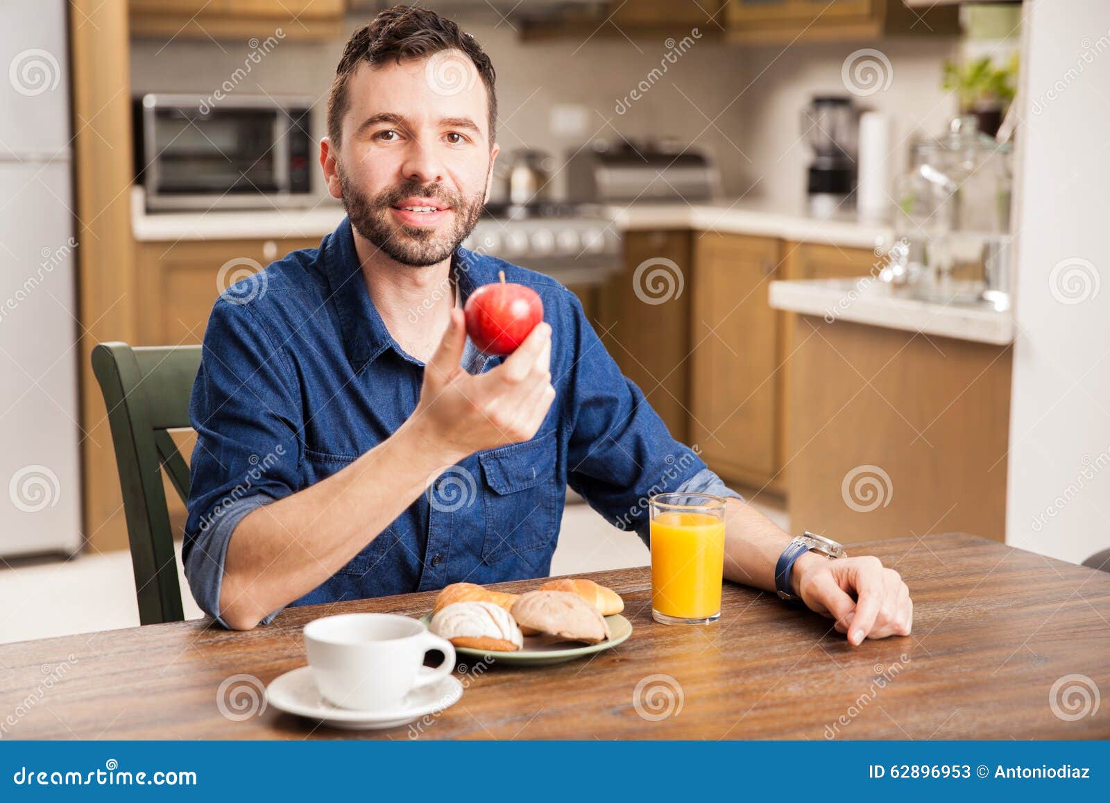 Young Man Eating Fruit at Home Stock Image - Image of casual, adult ...