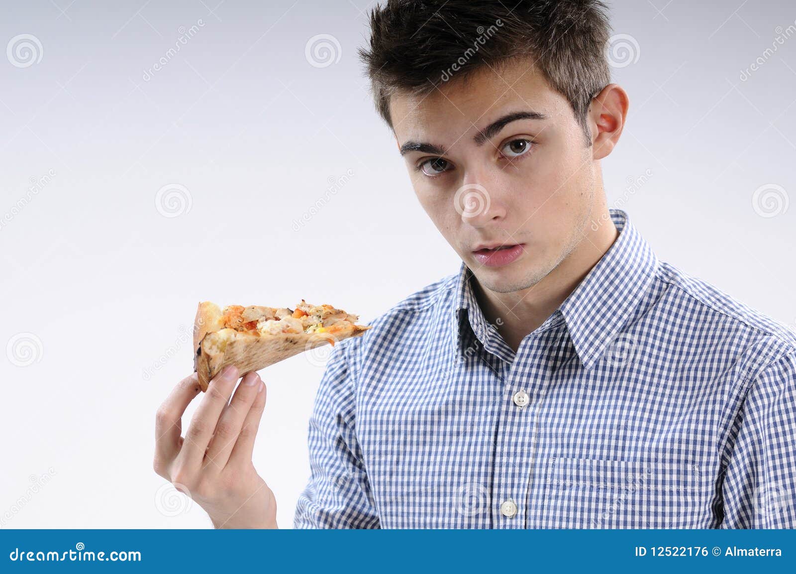 Young man eating pizza stock photo. Image of teenager - 12522176