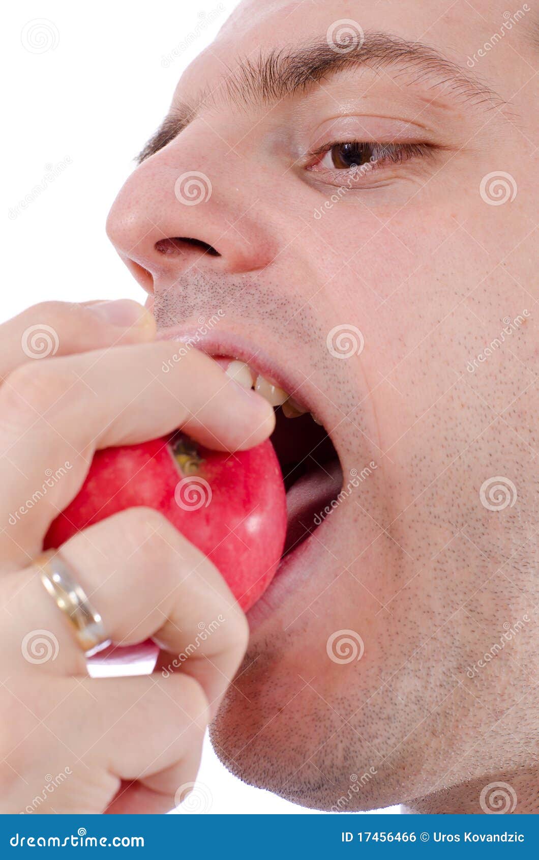 Young man Eating red apple stock photo. Image of isolated - 17456466
