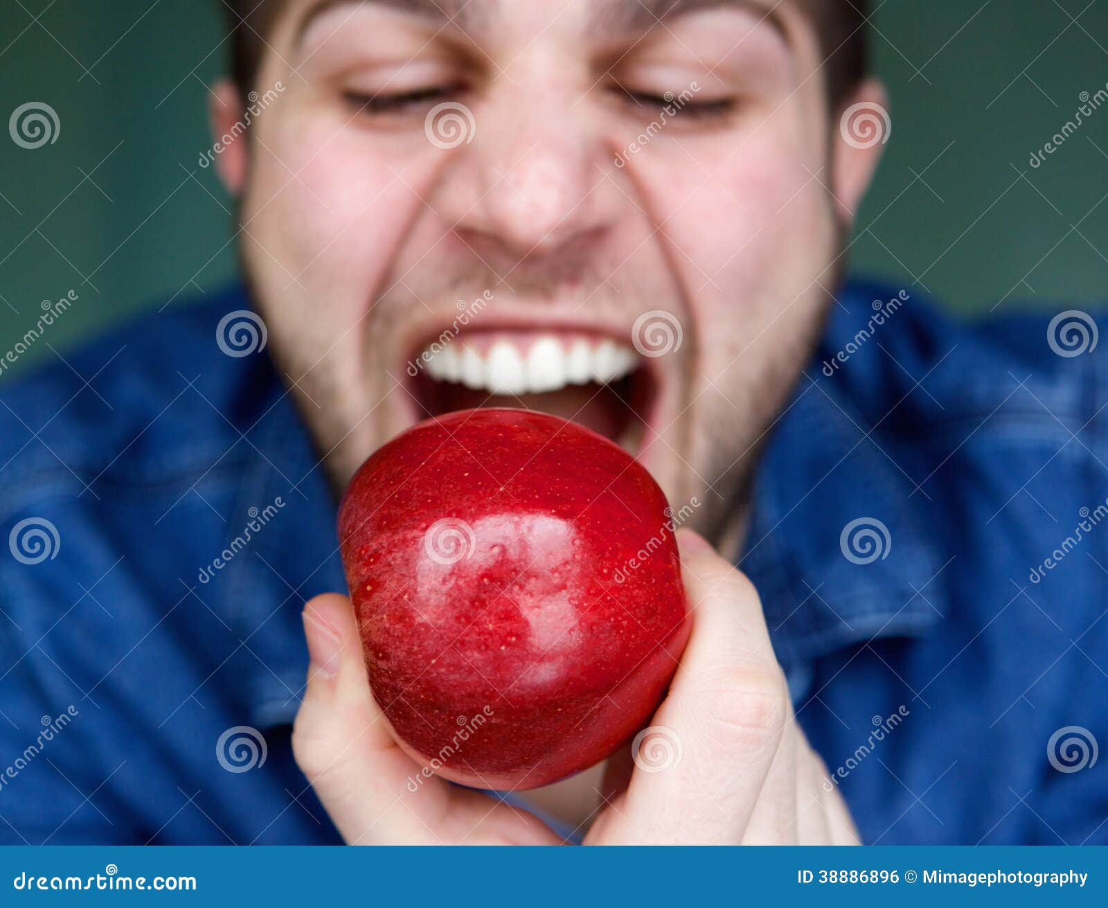 Young man eating red apple stock photo. Image of delicious - 38886896