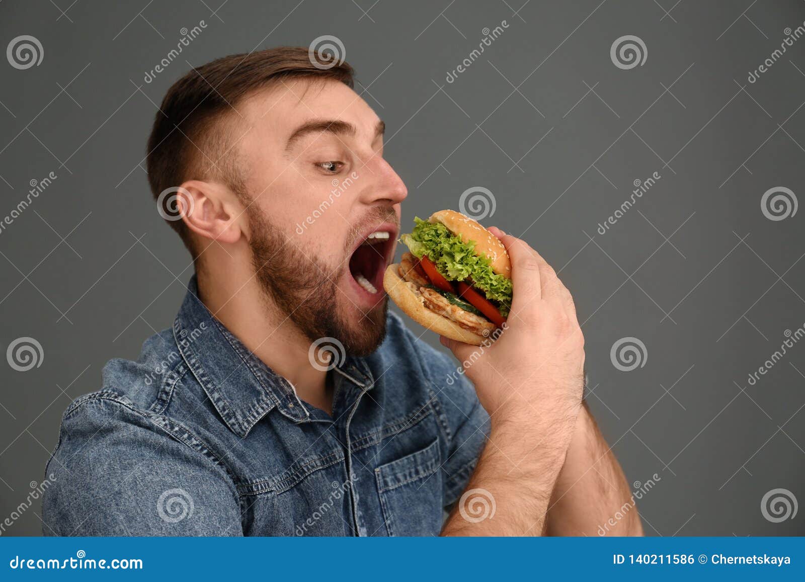 Young Man Eating Tasty Burger Stock Photo - Image of fresh, delicious ... Young Man Eating Tasty Burger Stock Photo - Image of fresh, delicious ...