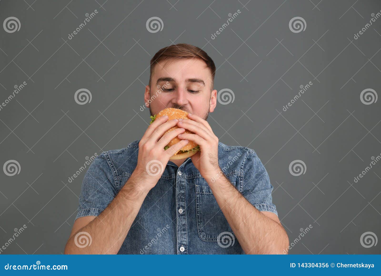 Young Man Eating Tasty Burger on Grey Stock Photo - Image of food ... Young Man Eating Tasty Burger on Grey Stock Photo - Image of food ...