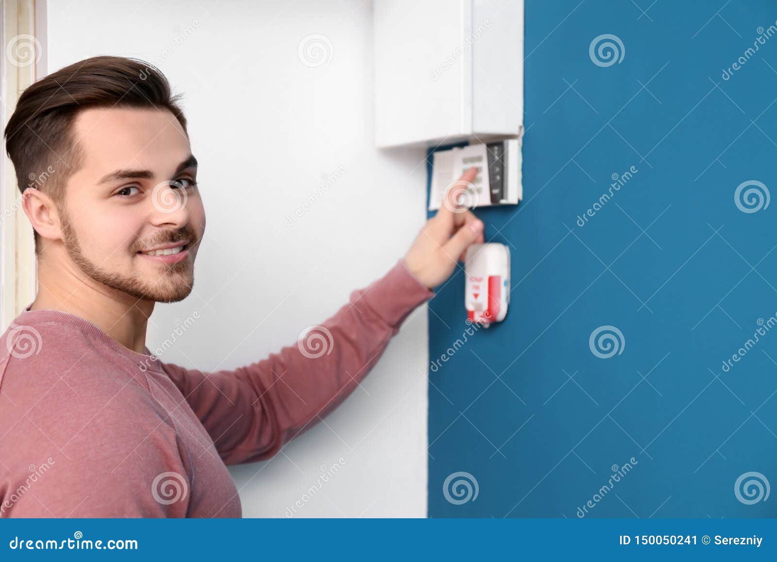 Young Man Entering Code on Security Alarm System, Indoors Stock Image ...