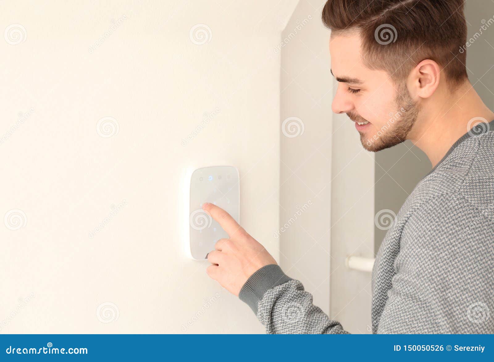 Young Man Entering Code on Security Alarm System, Indoors Stock Photo ...
