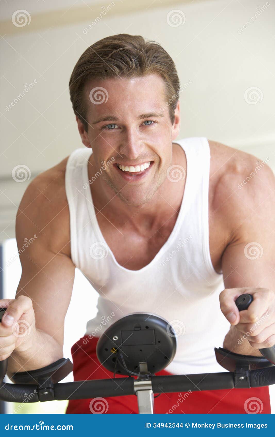 Young Man on Exercise Bike stock photo. Image of training - 54942544