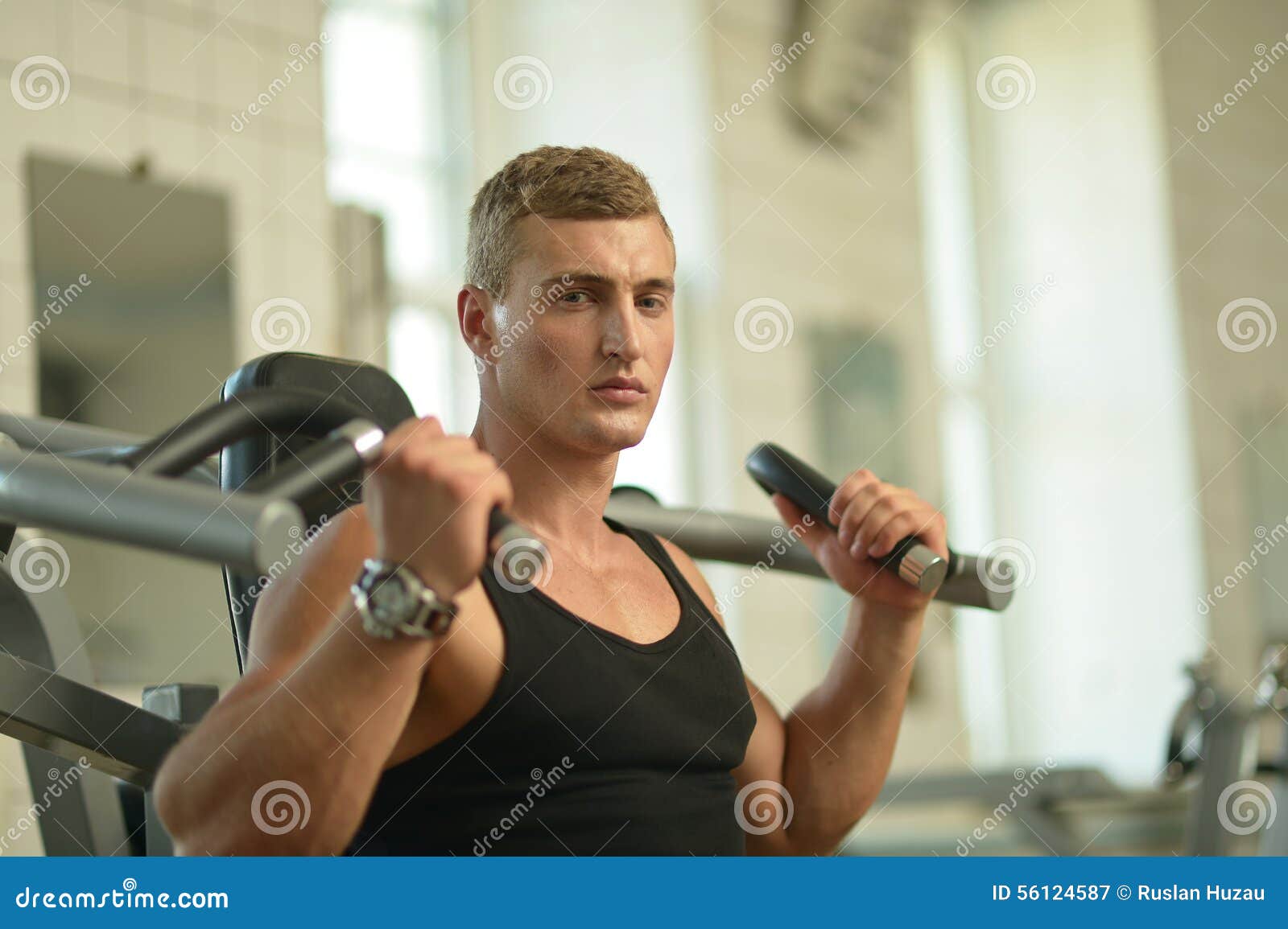 Young man exercises in gym stock image. Image of health - 56124587