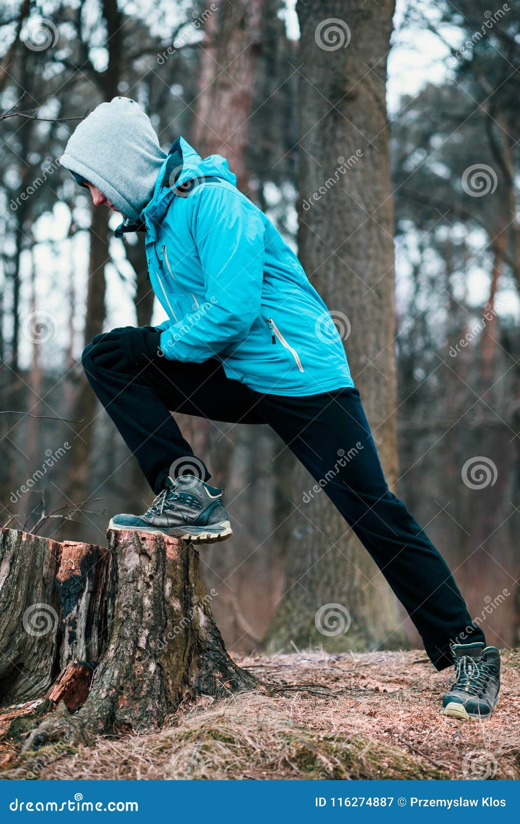 Young Man Exercising Outdoors in a Forest among Leafless Trees O Stock ...