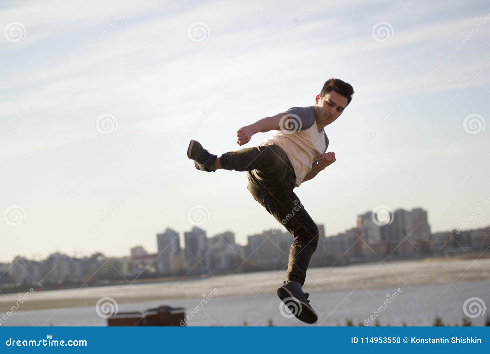 Young Male Kick Fighter Performs Acrobatic Kick in Front of Skyline ...