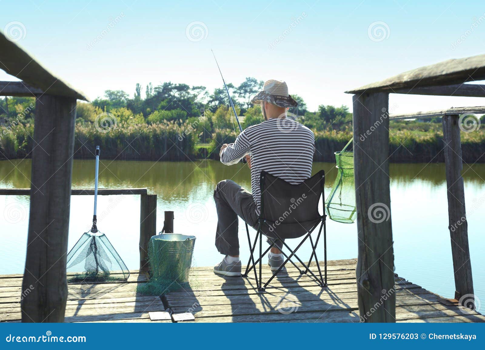 Young man fishing alone stock image. Image of pier, hobby - 129576203