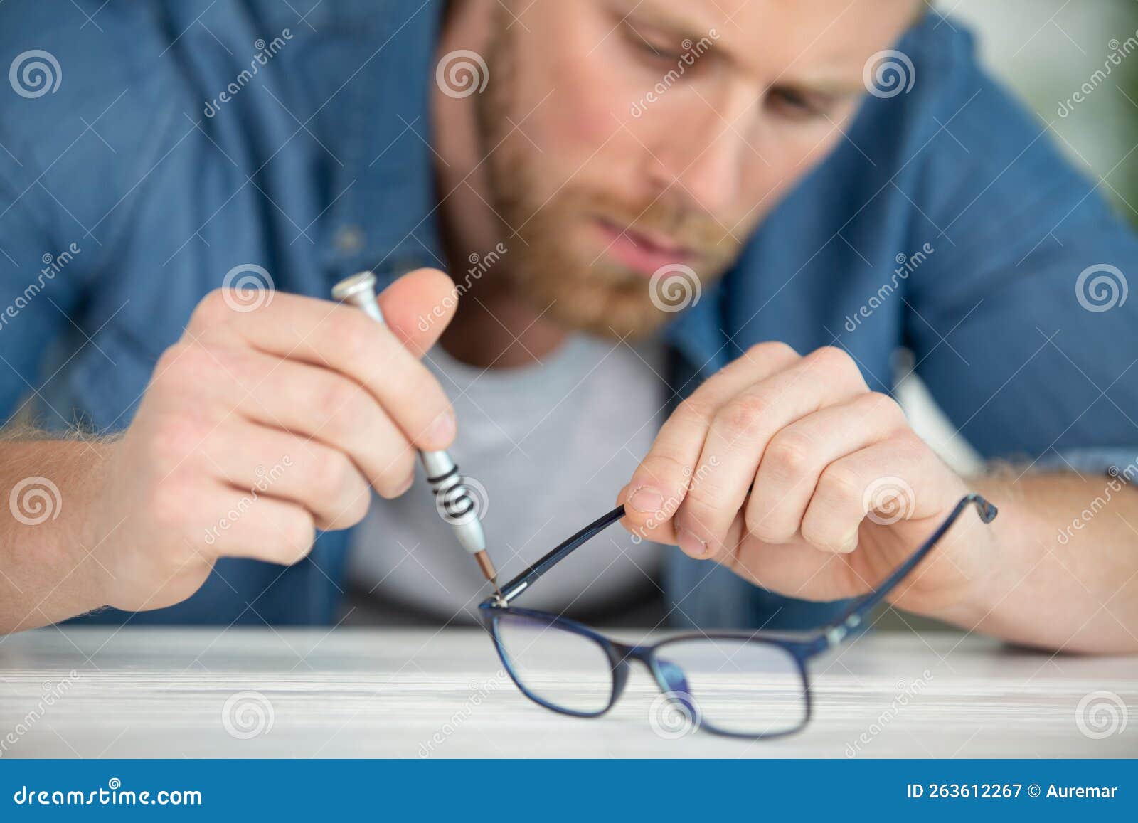 Young Man Fixing Glasses with Bending Pliers Stock Image - Image of ...