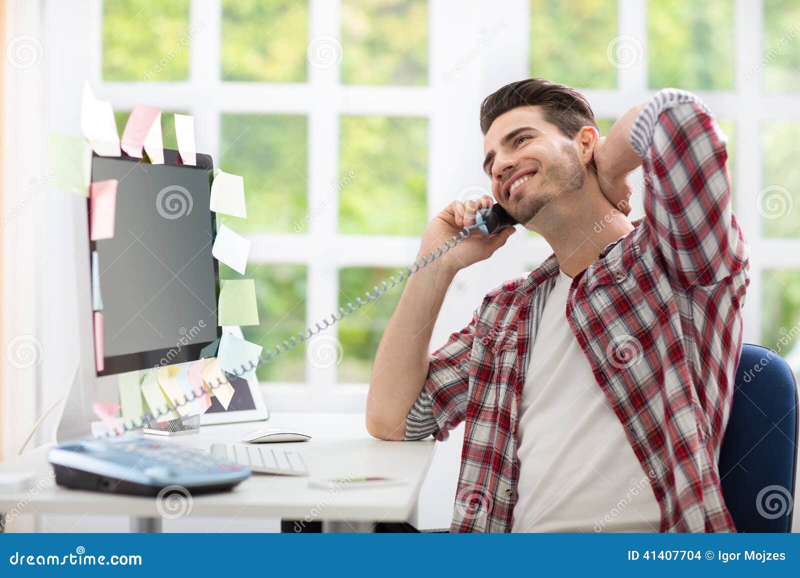 Young Man in Front of Computer Talking on Phone Stock Photo - Image of ...