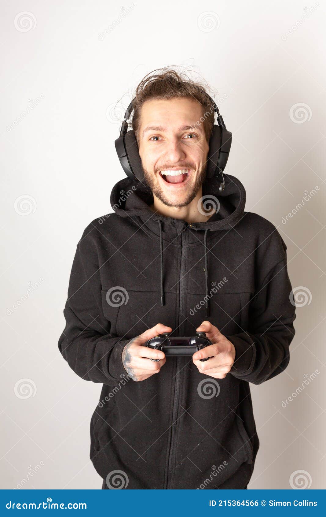Young Man with a Gaming Headset and Controller Having Fun Playing a ...