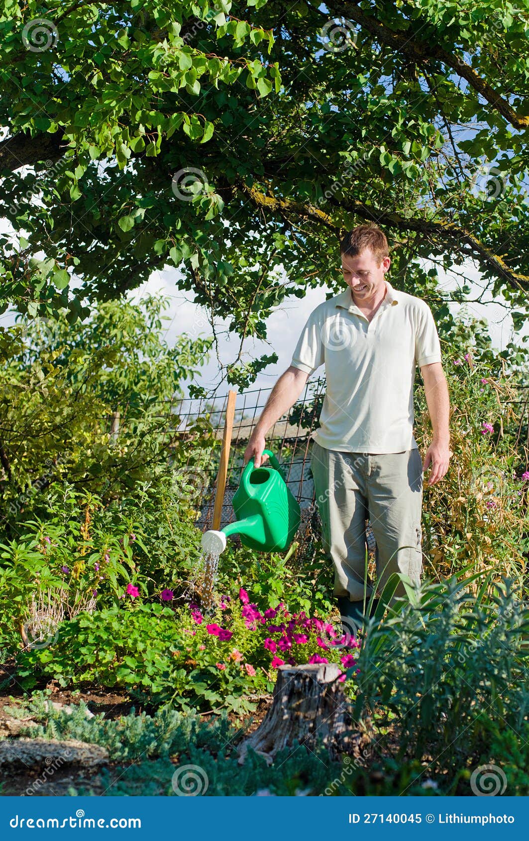 Young Man Gardener Watering Flowers In The Garden Stock Image Image