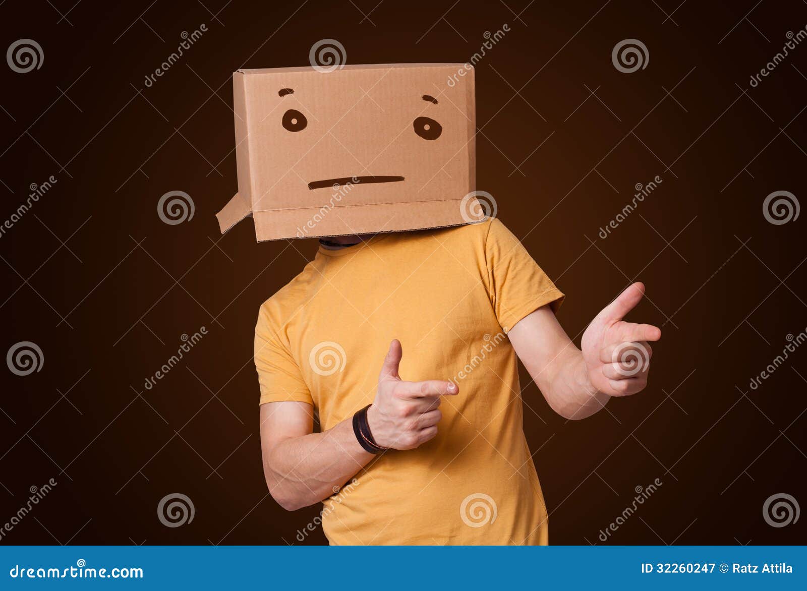 Young Man Gesturing with a Cardboard Box on His Head with Straight Face ...