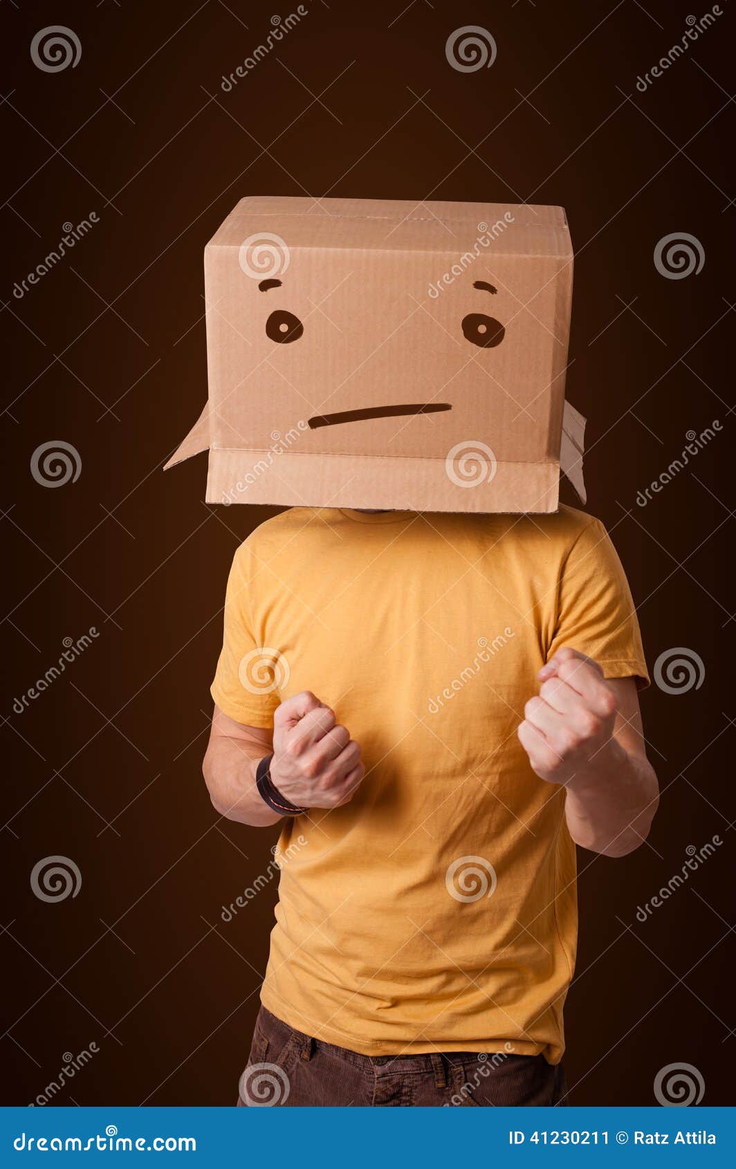 Young Man Gesturing with a Cardboard Box on His Head with Straight Face ...