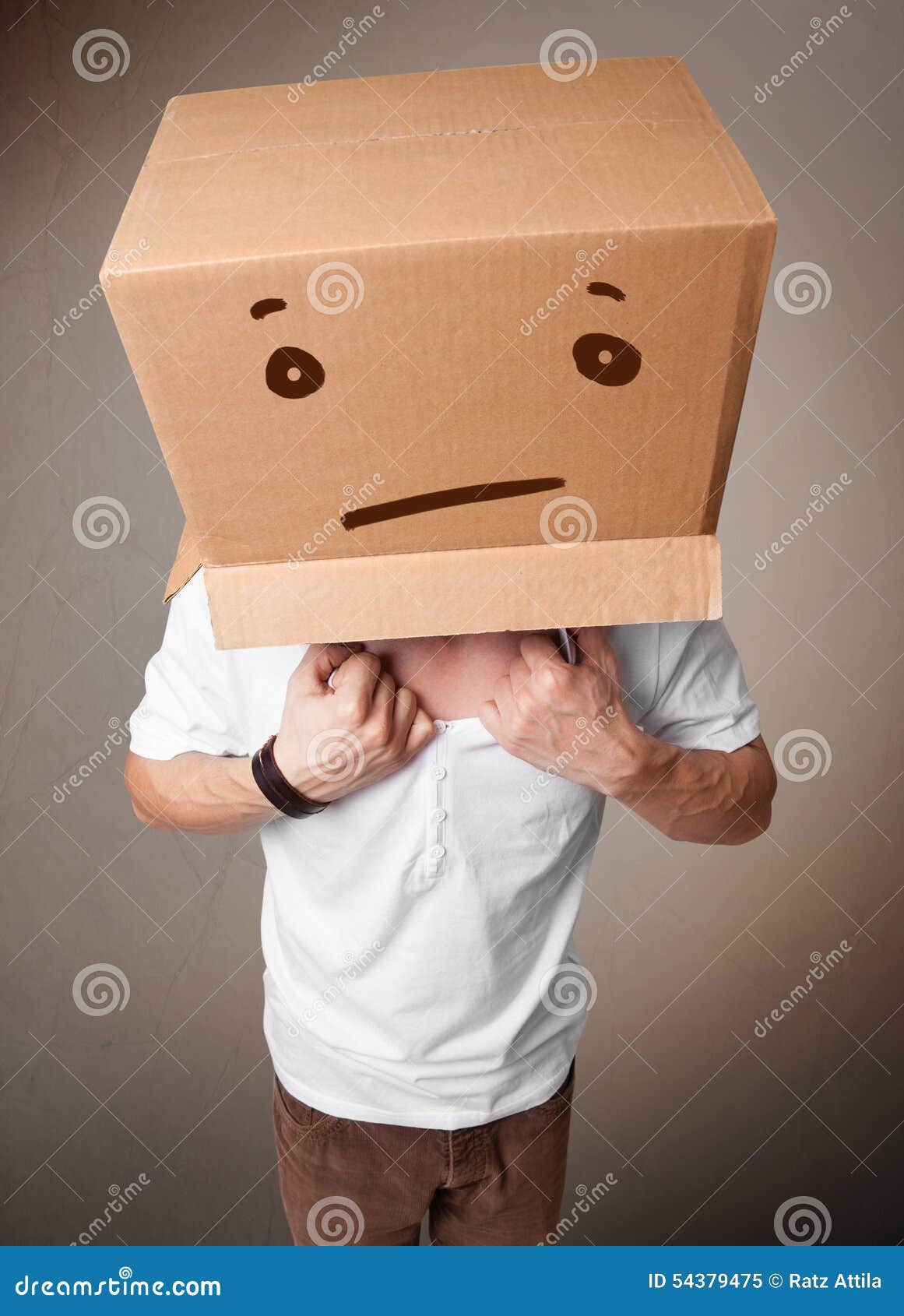 Young Man Gesturing with a Cardboard Box on His Head with Straight Face ...