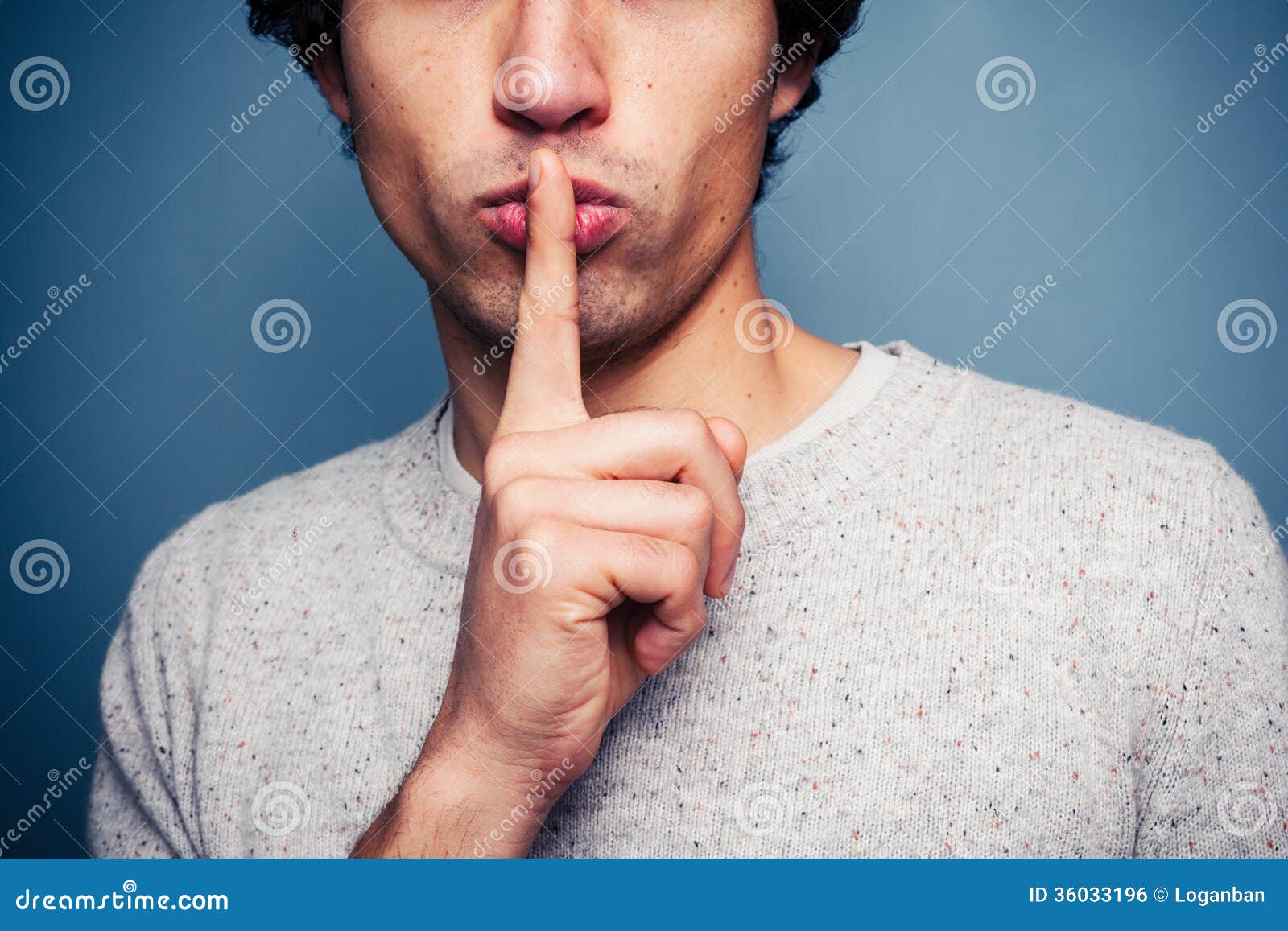 Young Man Gesturing Hush with Finger on Lips Stock Photo - Image of ...