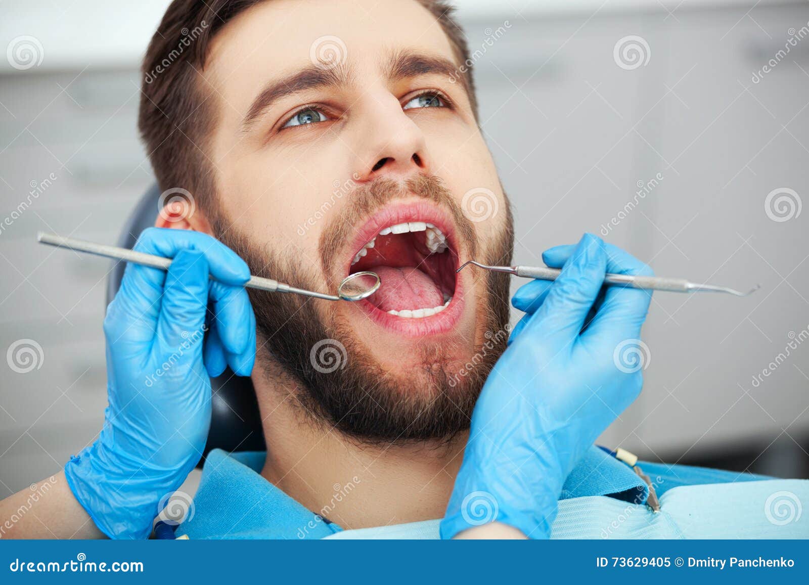 Young Man Getting His Teeth Checked by a Dentist. Stock Image - Image ...