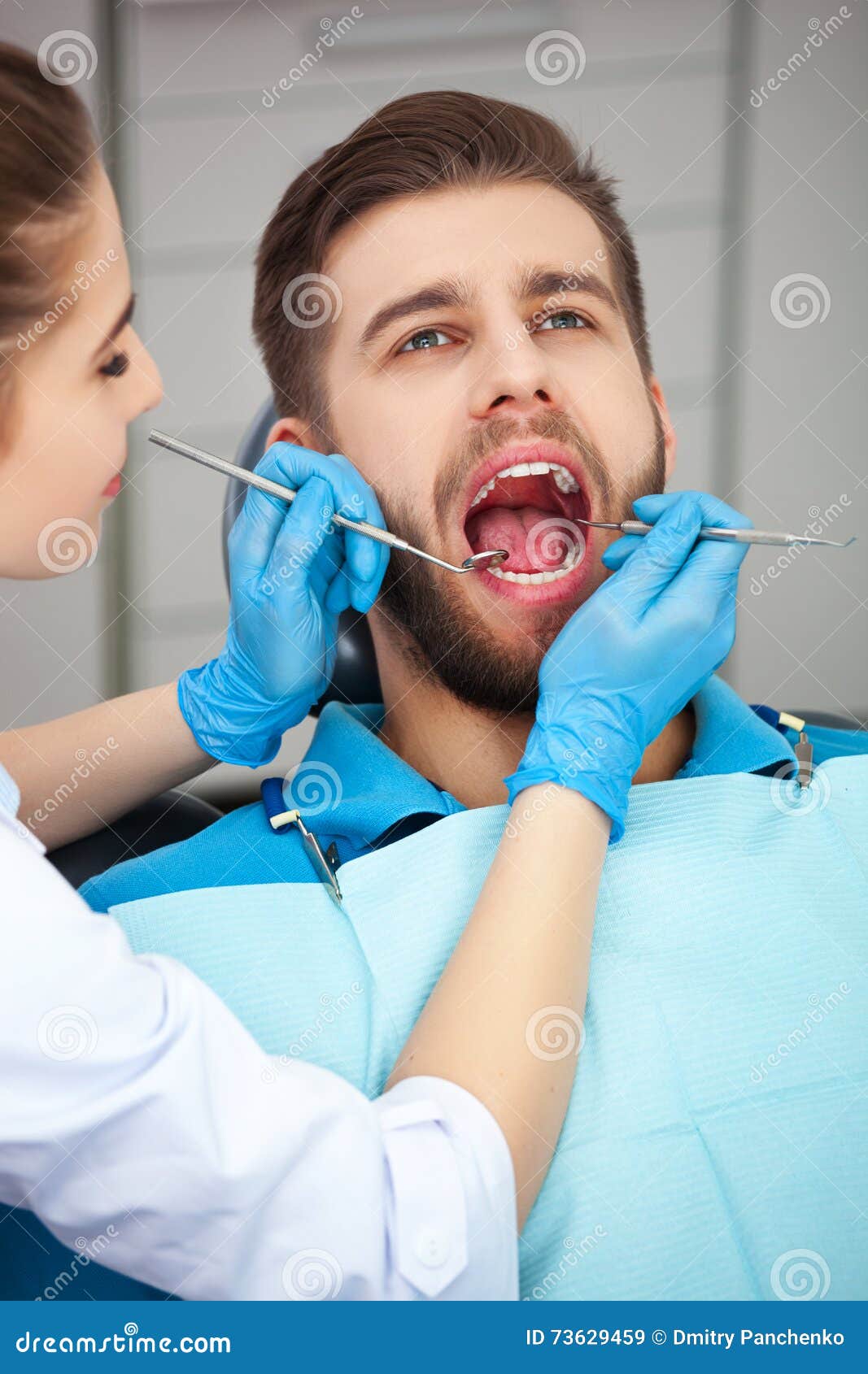 Young Man Getting His Teeth Checked by a Dentist. Stock Image - Image ...