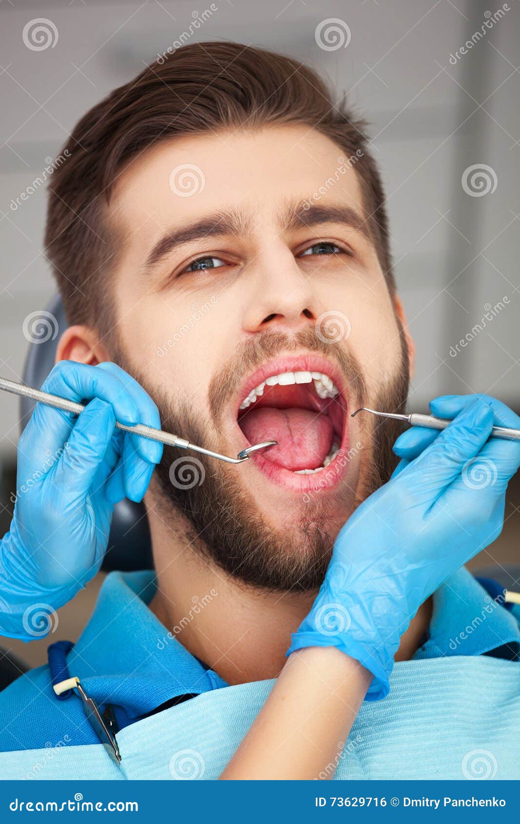 Young Man Getting His Teeth Checked by a Dentist. Stock Photo - Image ...