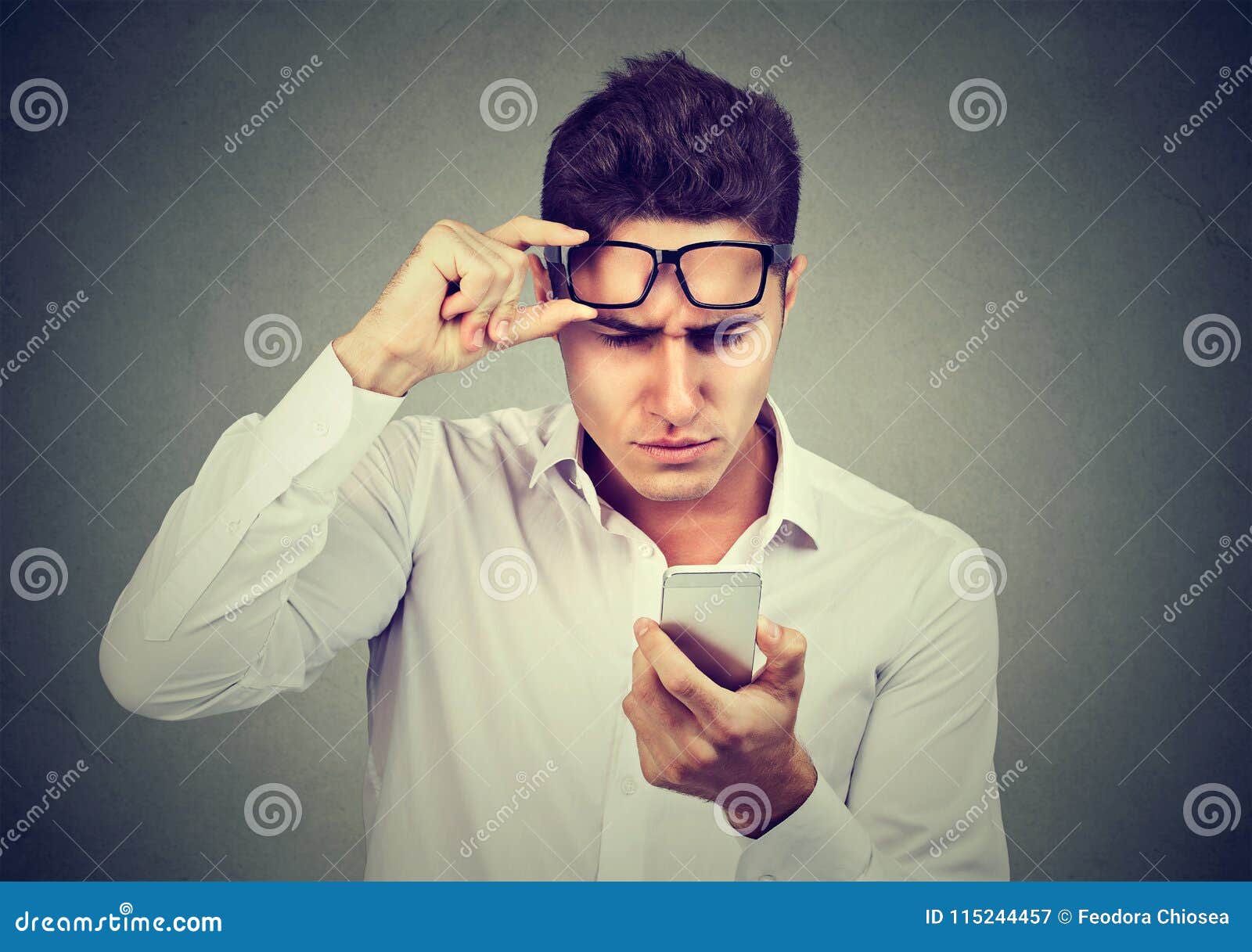Young Man with Glasses Having Trouble Seeing Cell Phone Has Vision ...