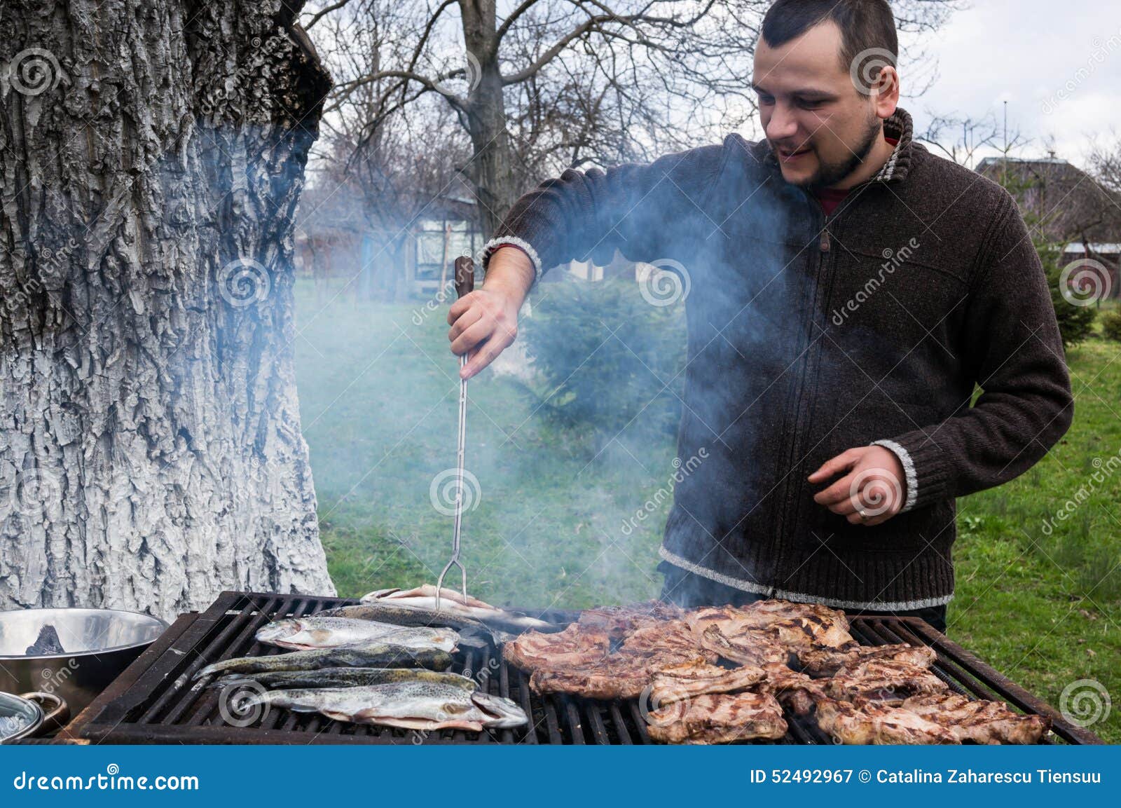 Young Man Grilling Pork and Fish Stock Image - Image of young, adult ...