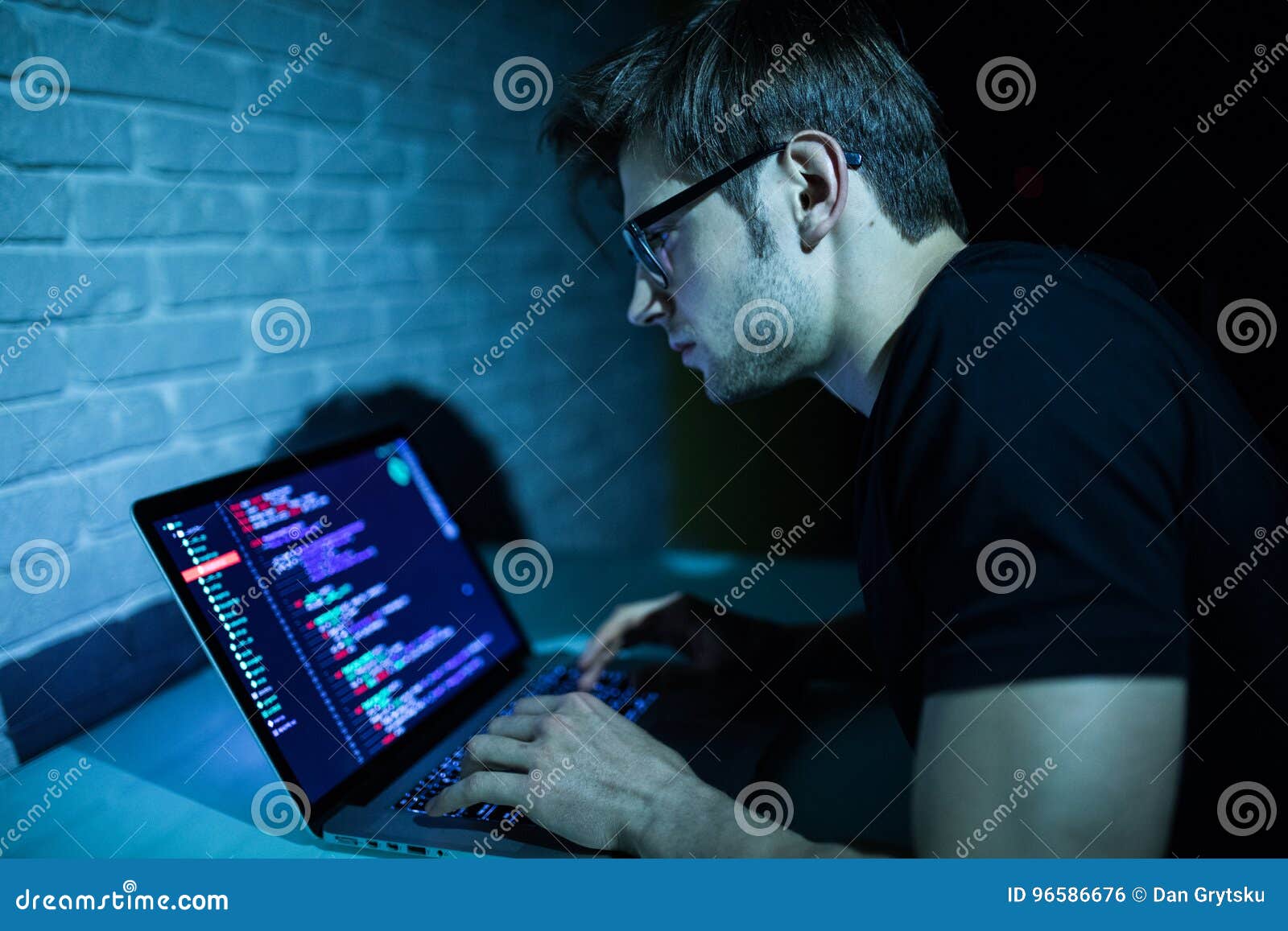 Young Man Hacker Working on Laptop Attack the Network Software in Night ...